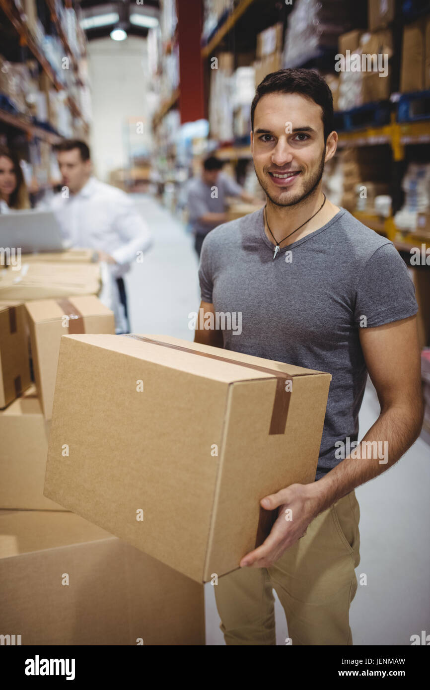 Smiling man carrying box Stock Photo - Alamy