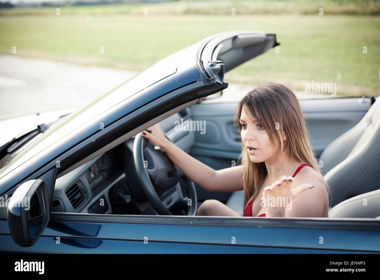 angry girl in red dress driving a convertible Stock Photo - Alamy