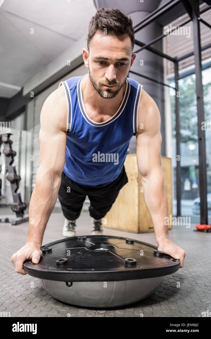 Muscular man doing push up on bosu ball Stock Photo - Alamy