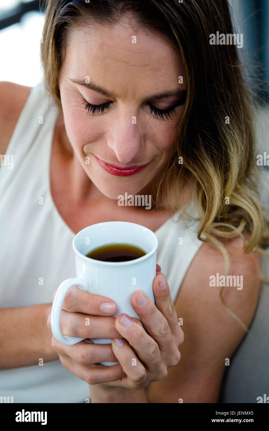 smiling woman sipping a cup of coffee Stock Photo - Alamy