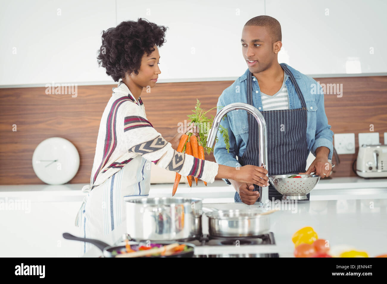 Happy couple washing vegetables Stock Photo - Alamy