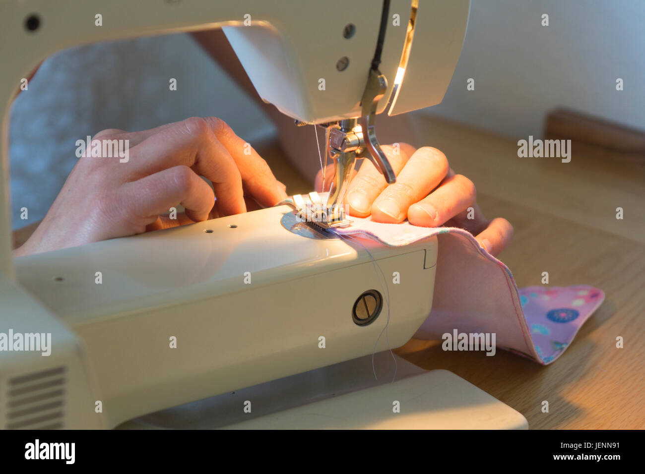A young woman using a sewing machine Stock Photo - Alamy