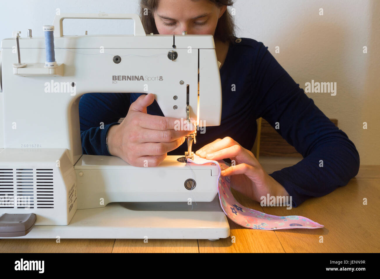 A young woman using a sewing machine Stock Photo - Alamy