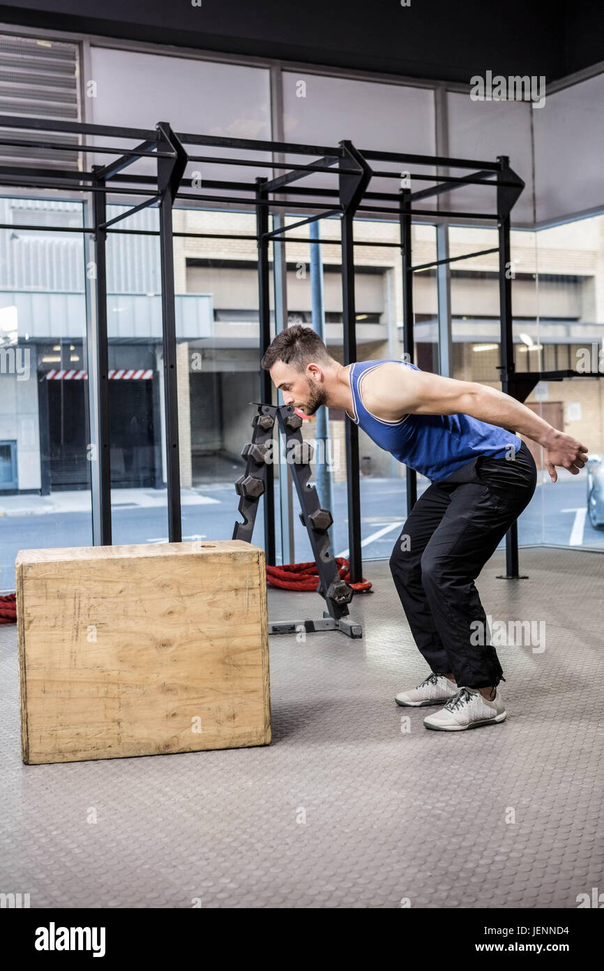 Muscular man jumping on wooden block Stock Photo - Alamy