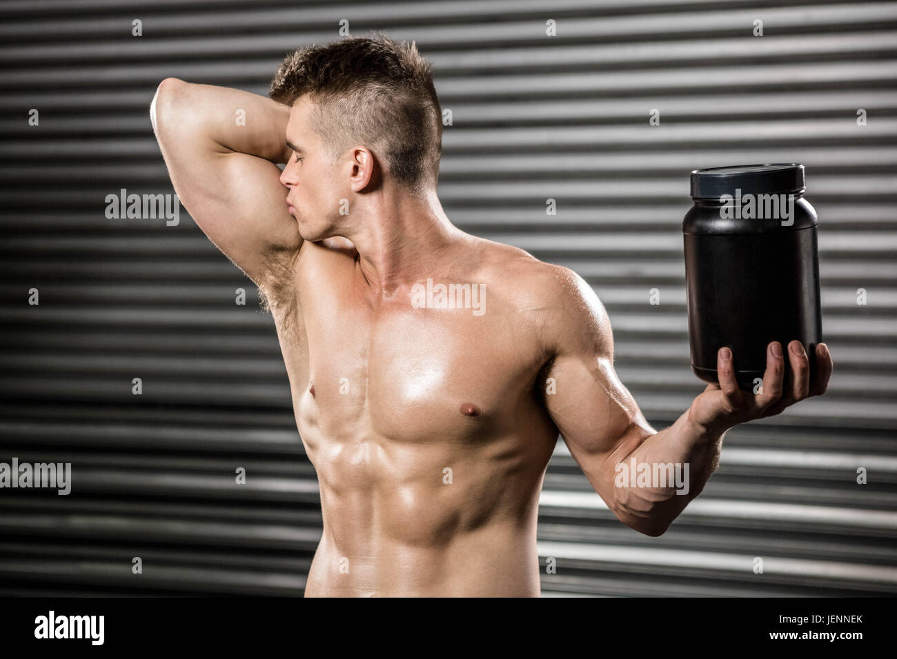 Shirtless man kissing biceps and holding can Stock Photo - Alamy