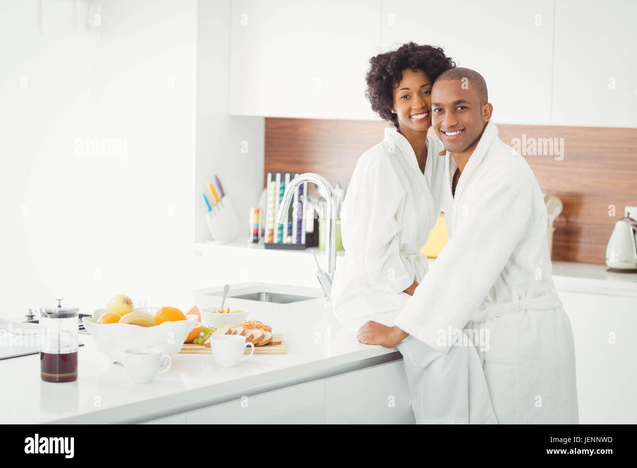 Happy couple hugging in the kitchen Stock Photo - Alamy