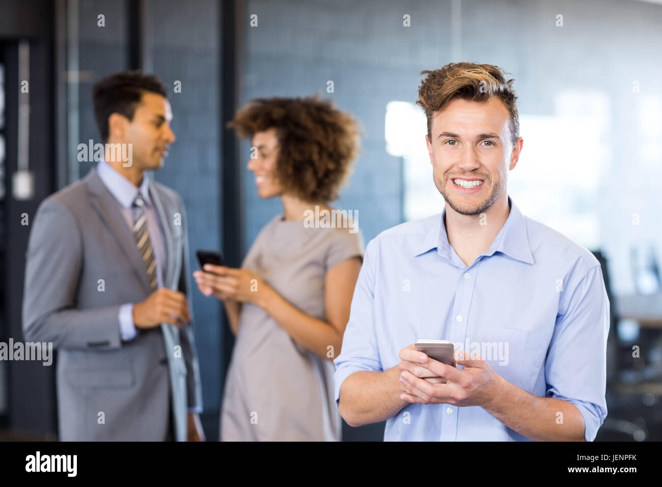 Confident executive using mobile phone Stock Photo - Alamy