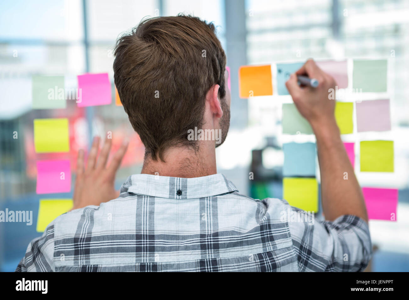 Hipster man writing on post-it Stock Photo - Alamy