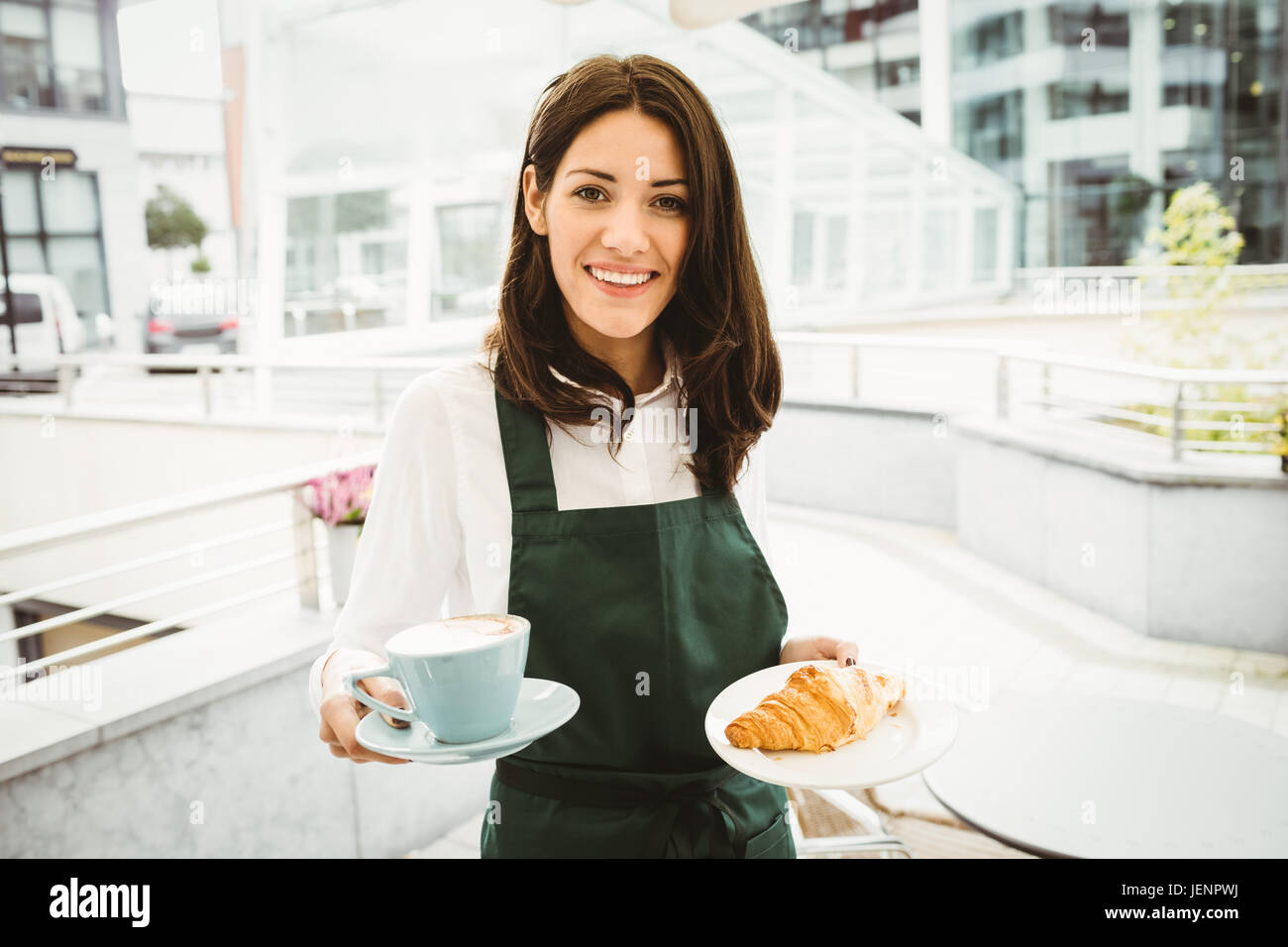 Waitress posing with coffee and croissant Stock Photo - Alamy