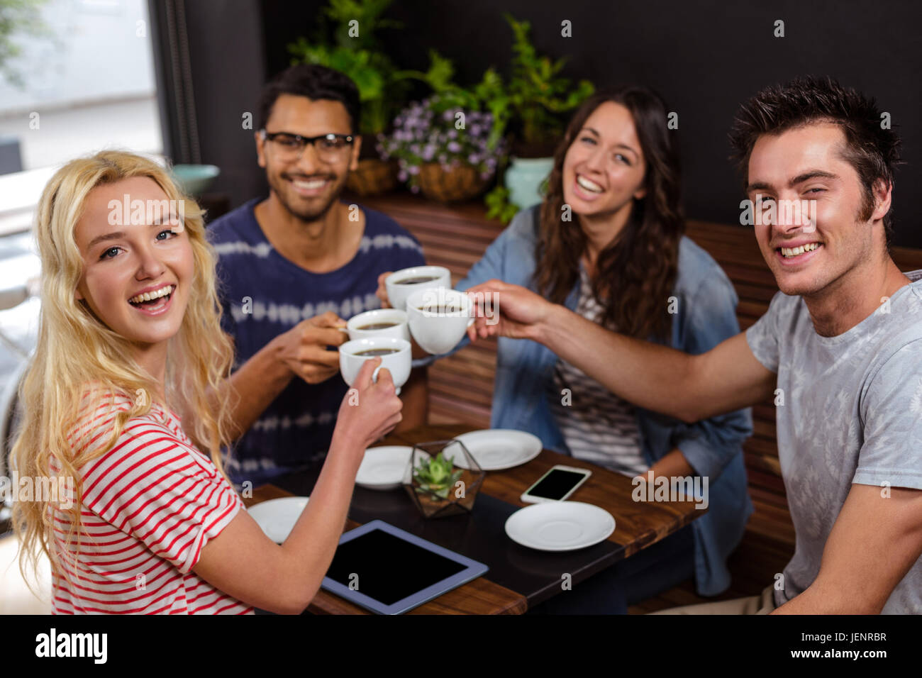 Smiling friends enjoying coffee together Stock Photo - Alamy