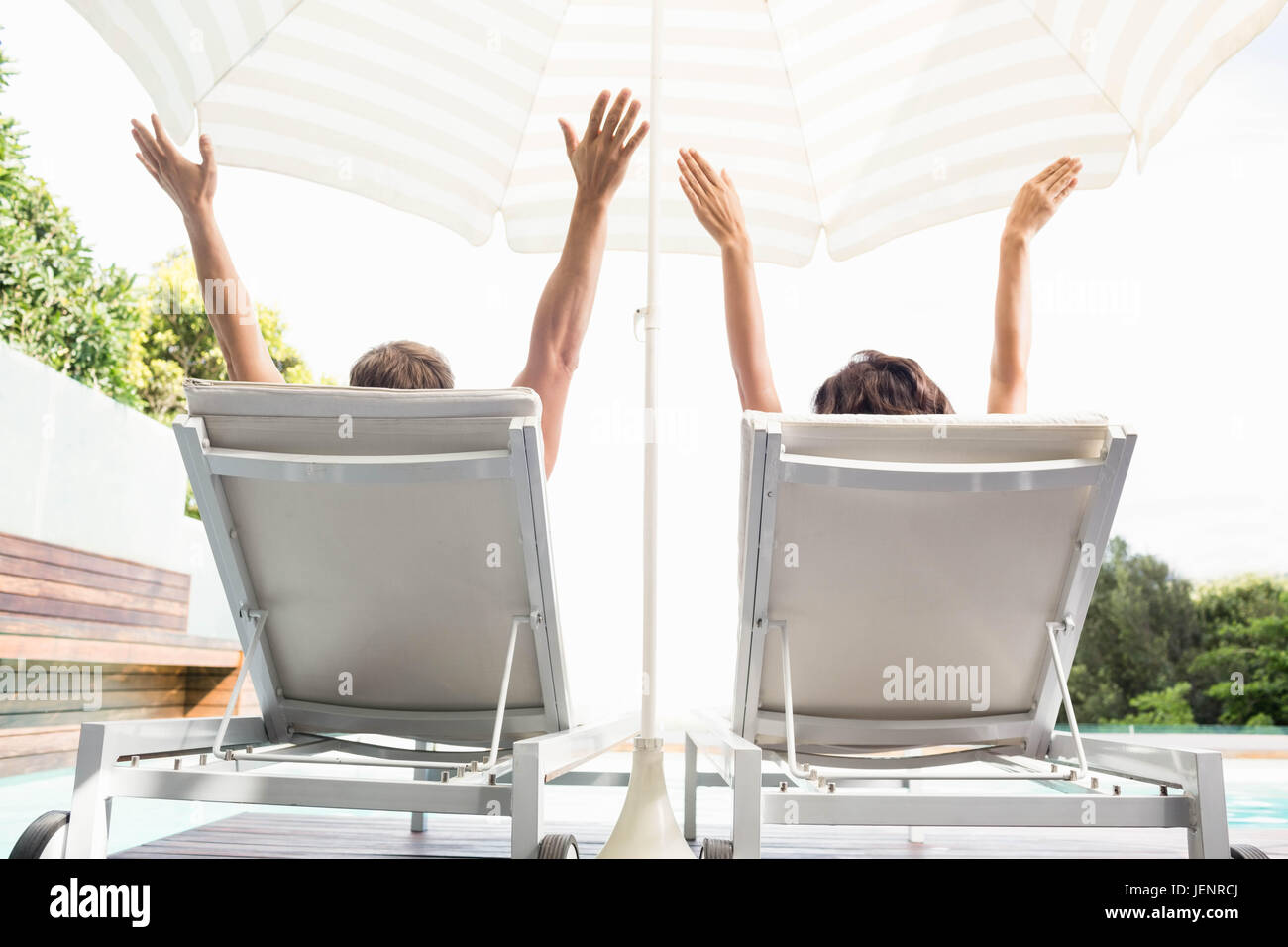 Couple sitting near swimming pool hi-res stock photography and images ...