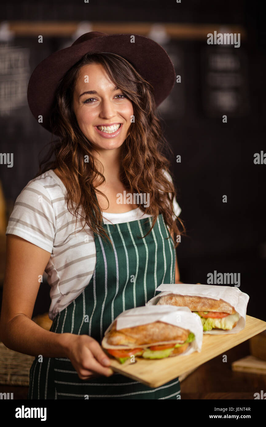 Smiling barista holding sandwiches Stock Photo - Alamy