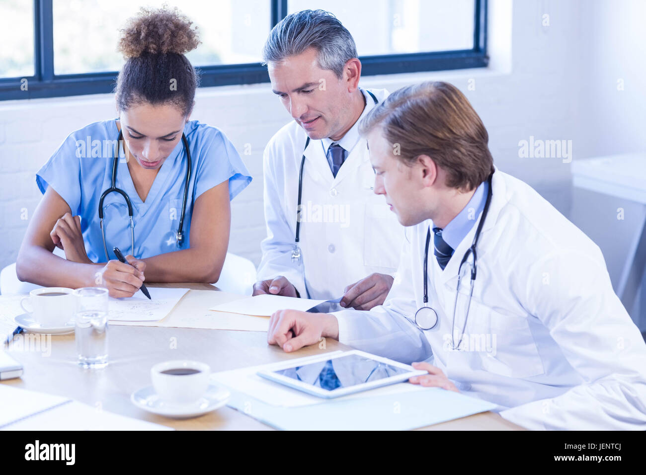 Medical team sitting discussing table hi-res stock photography and ...