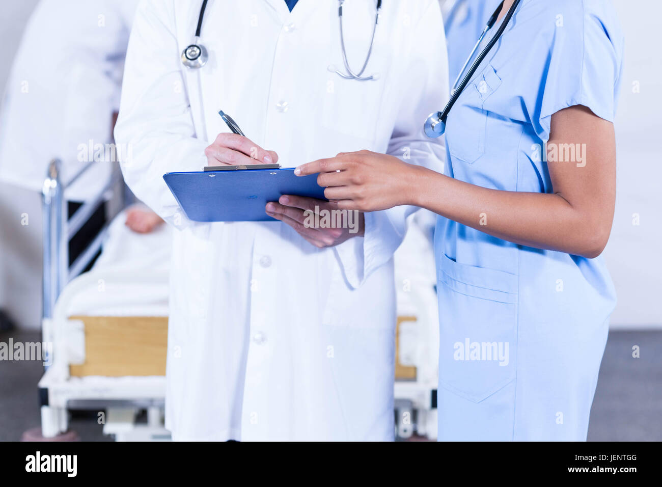 Doctors writing on clipboard Stock Photo - Alamy