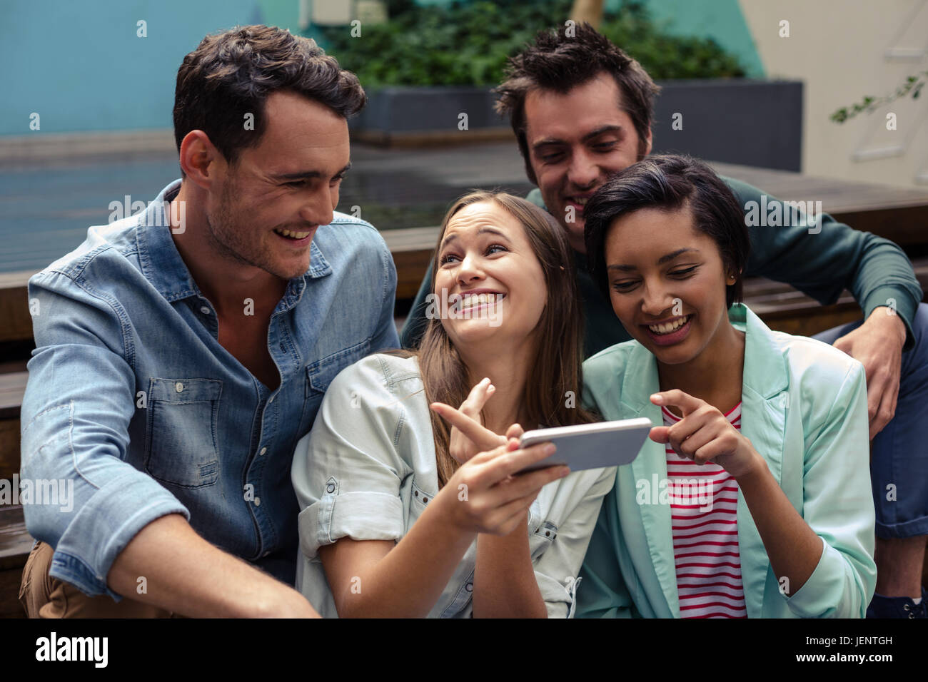 Happy friends using smartphone Stock Photo - Alamy