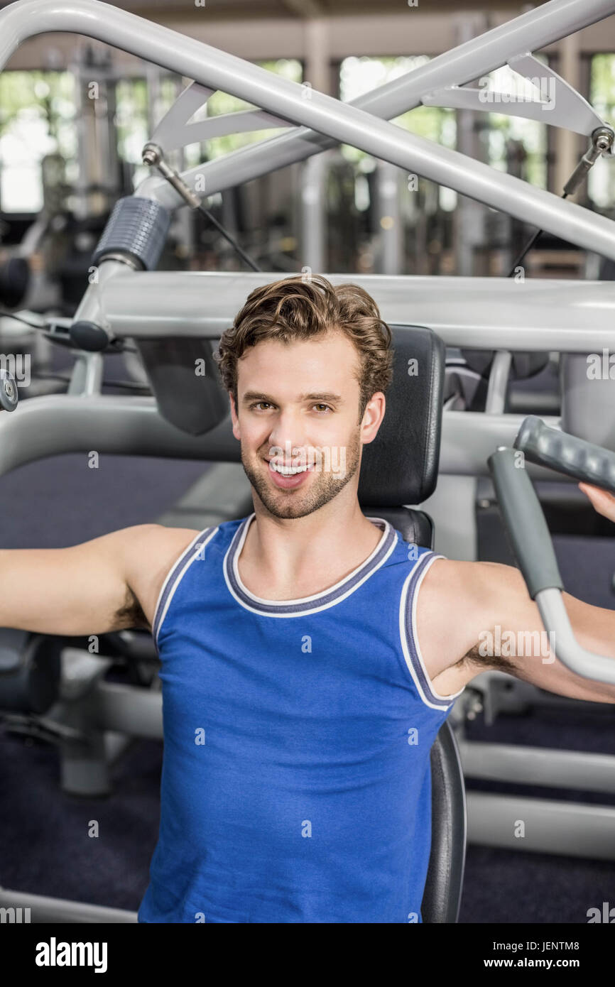 Fit man using weight machine Stock Photo - Alamy
