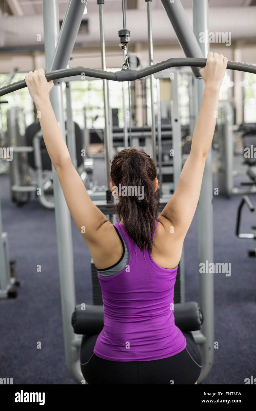Fit woman using weight machine Stock Photo - Alamy
