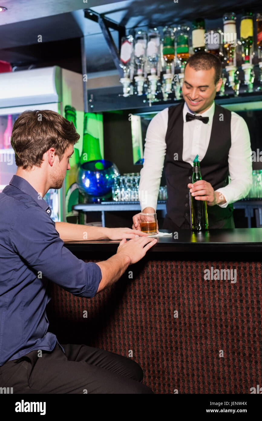 Bartender serving whiskey to man Stock Photo - Alamy
