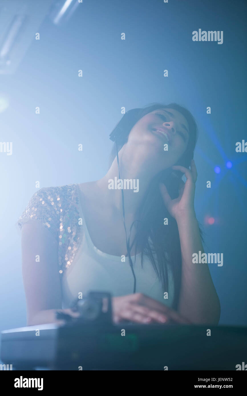 Pretty female DJ playing music Stock Photo - Alamy