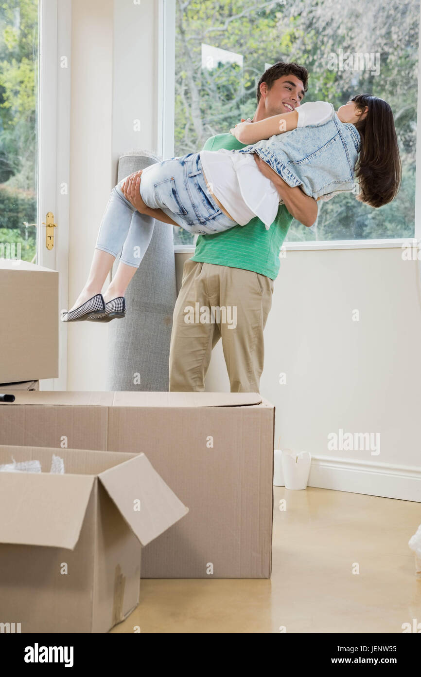 Young man lifting woman in his arms Stock Photo - Alamy