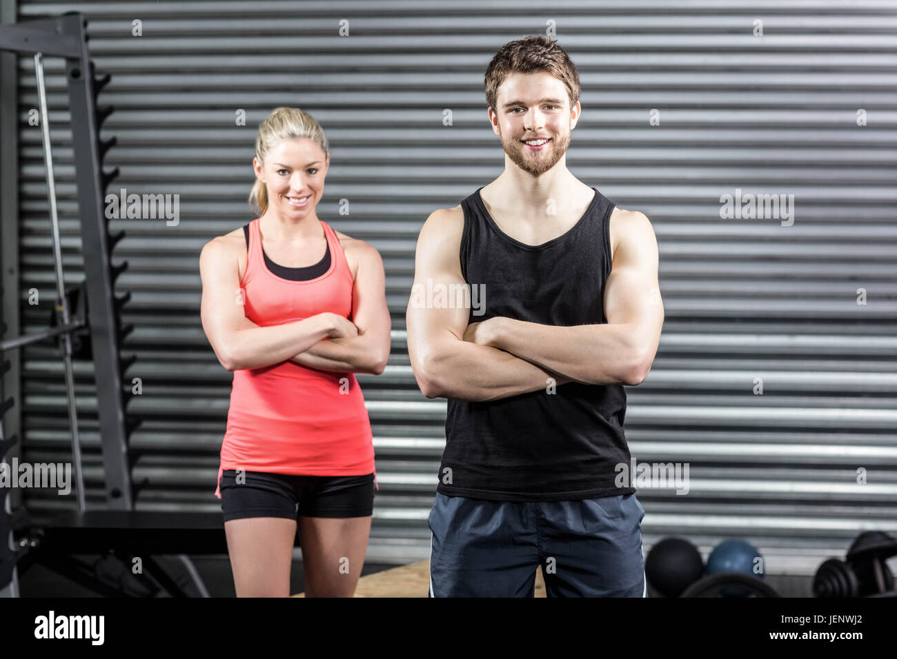 Fit couple with arm crossed Stock Photo - Alamy