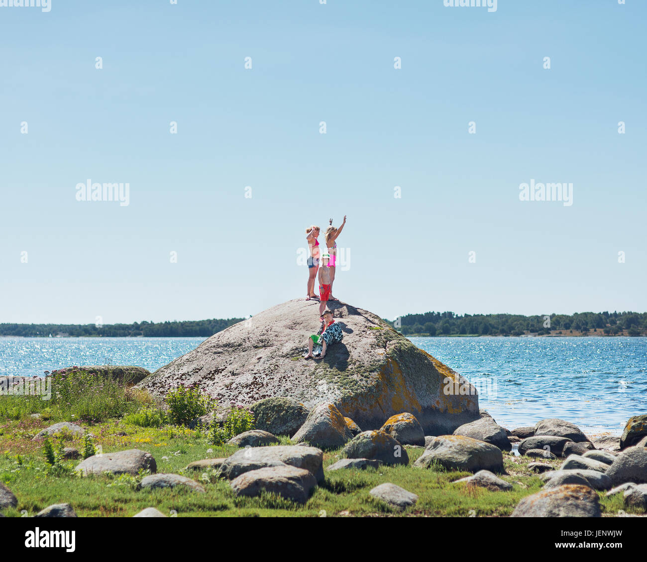 Children on rock at water Stock Photo - Alamy