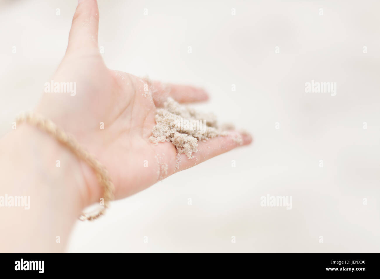 Womans hand holding sand Stock Photo - Alamy