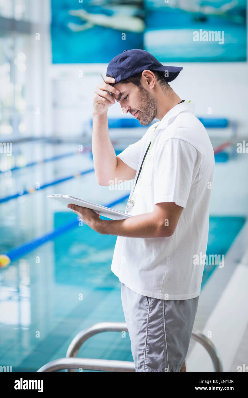 Smiling trainer holding clipboard Stock Photo - Alamy