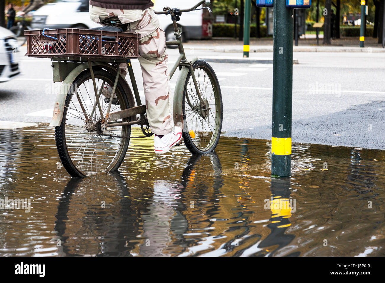 Person cycling through puddle Stock Photo - Alamy