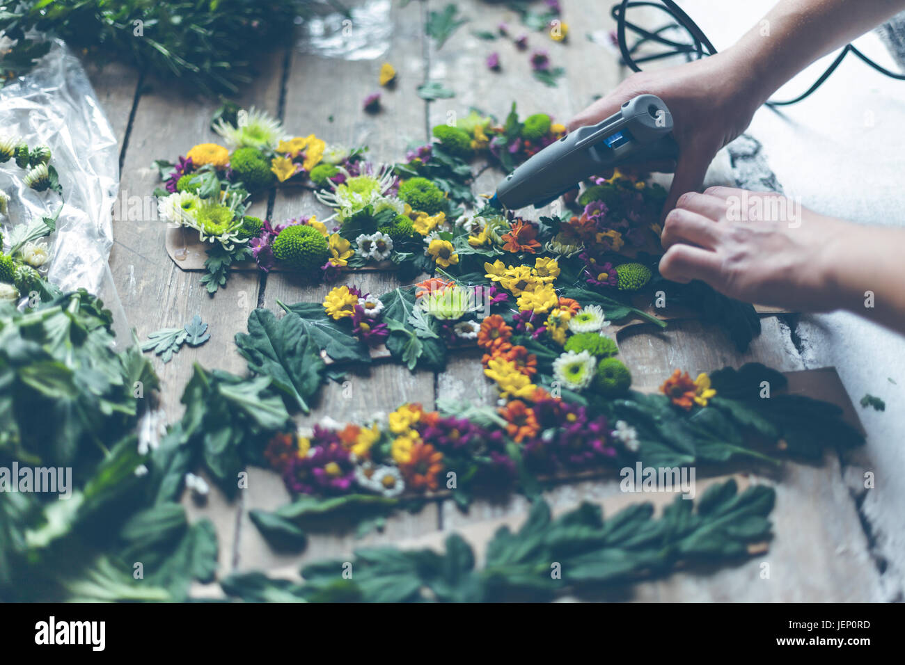 Florist making flower decoration with letters and glue. Indoors natural ...