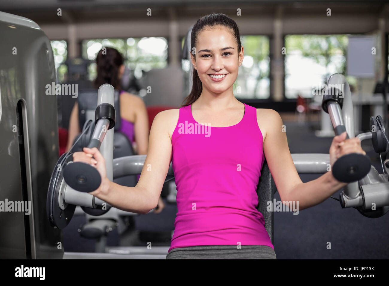 Fit woman using weight machine Stock Photo - Alamy
