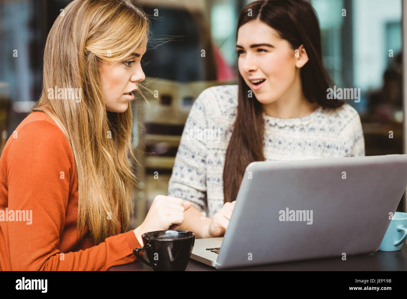 Friends using laptop together Stock Photo - Alamy