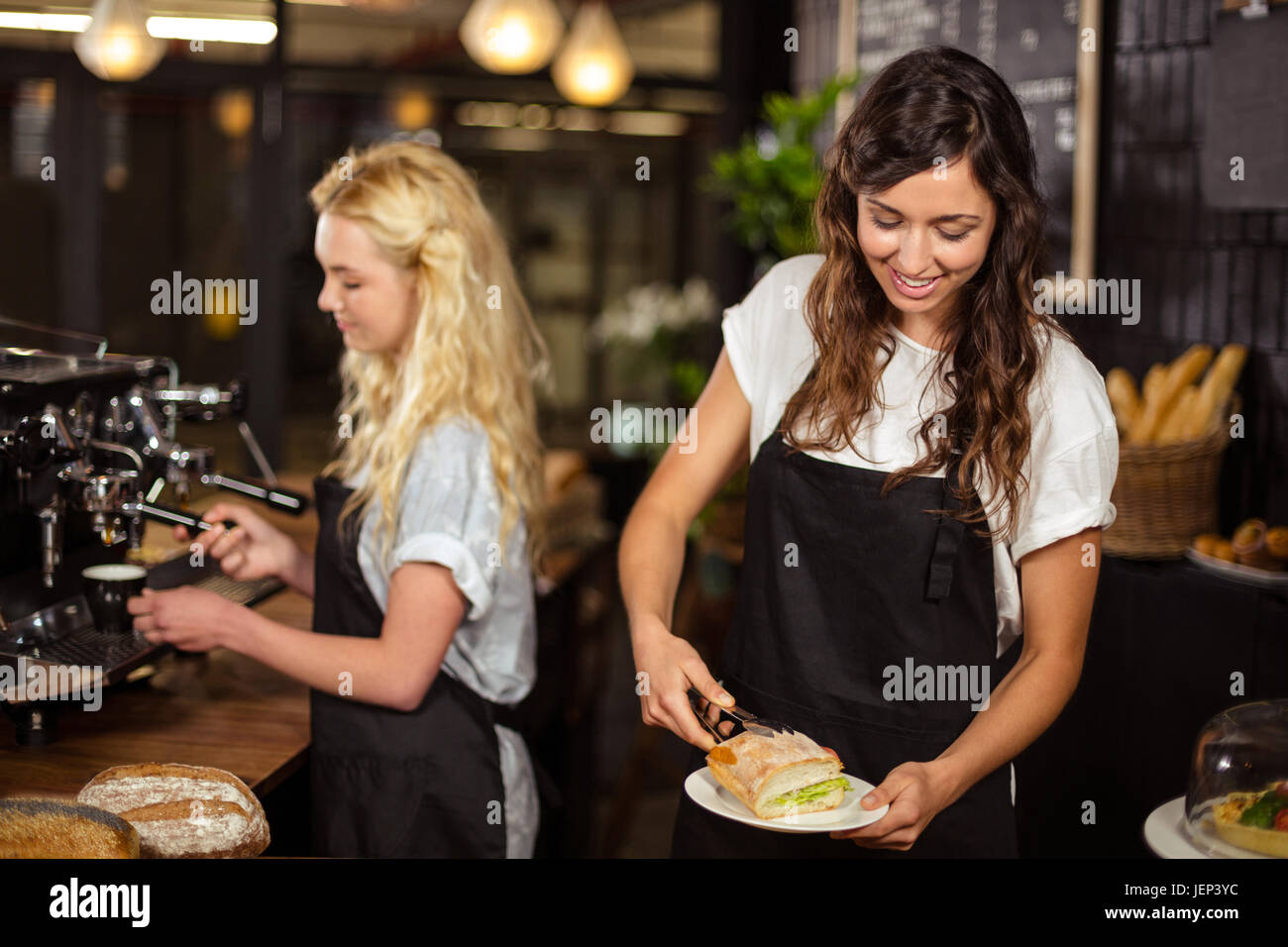 Pretty waitresses behind the counter working Stock Photo - Alamy
