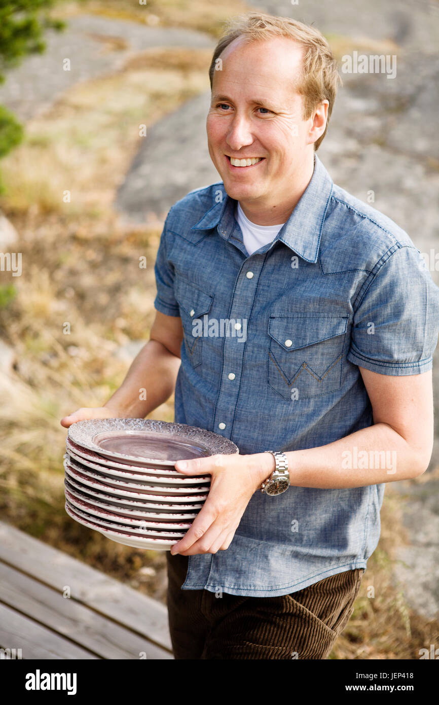 Man carrying plates Stock Photo - Alamy