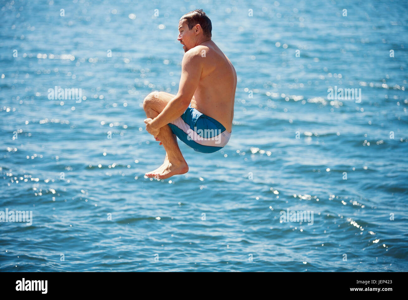 Man jumping into sea Stock Photo - Alamy
