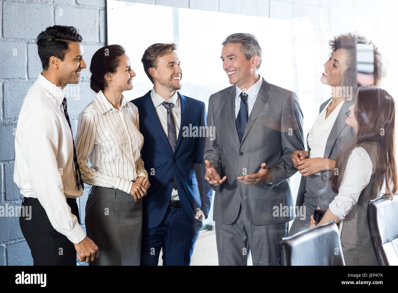 Businesspeople interacting in conference room Stock Photo - Alamy