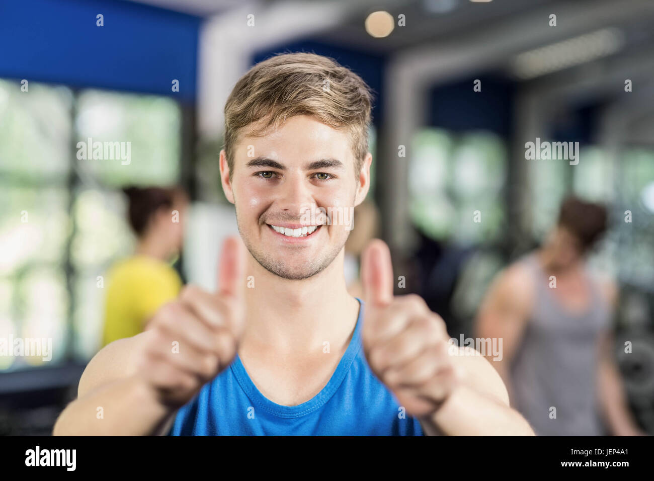 Muscular man posing with thumbs up Stock Photo - Alamy