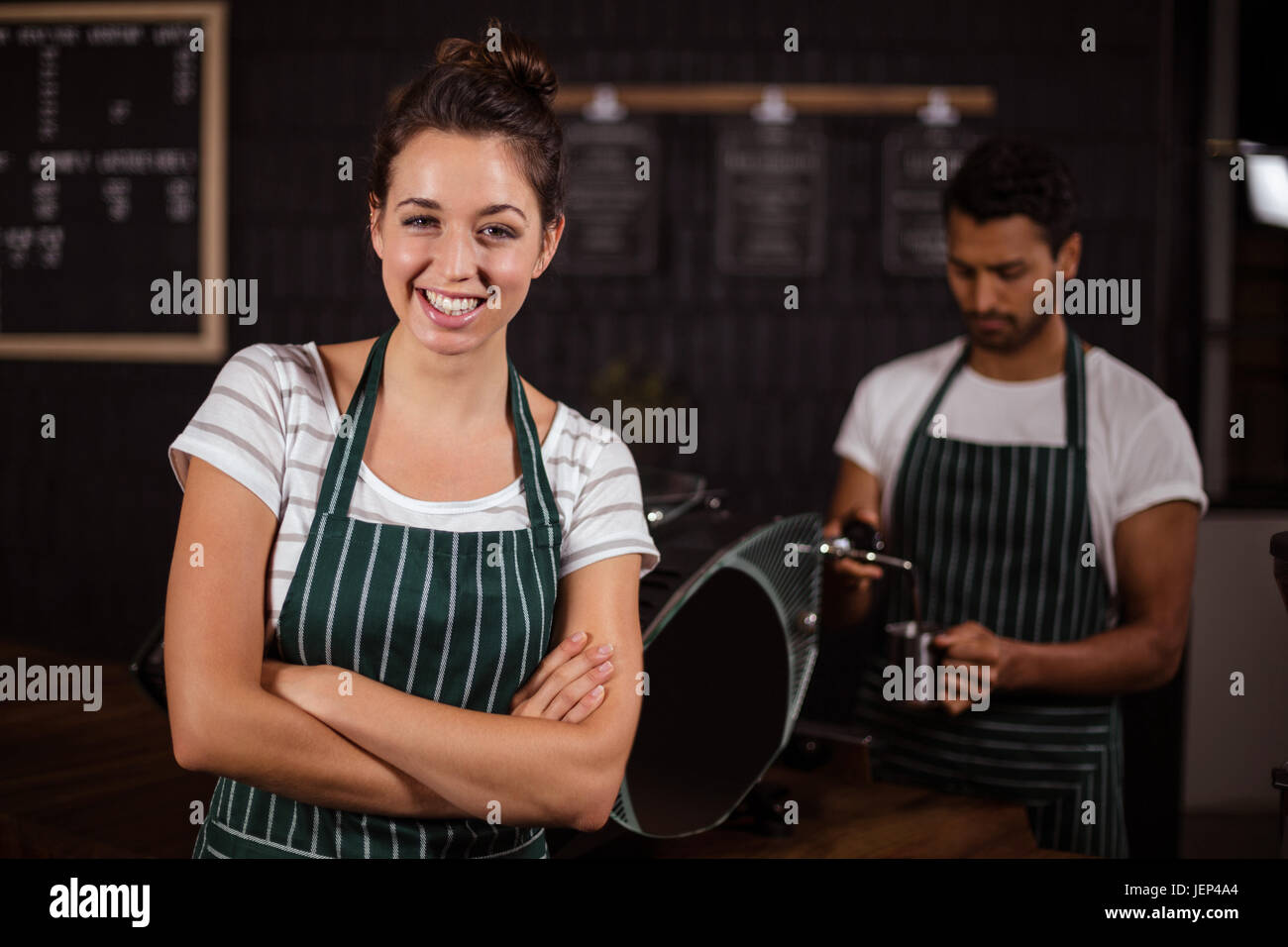 Smiling barista standing with arms crossed Stock Photo - Alamy