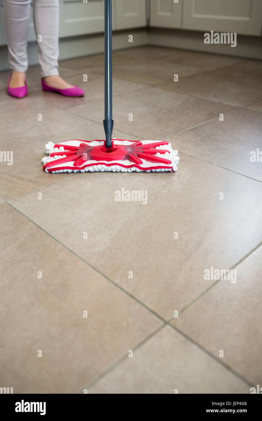 Woman swiping the kitchen floor Stock Photo - Alamy
