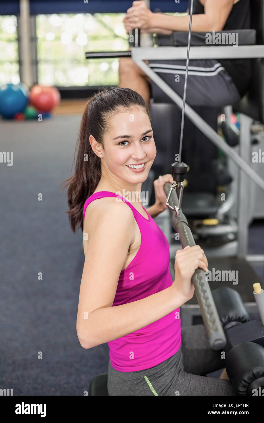 Fit woman using weight machine Stock Photo - Alamy