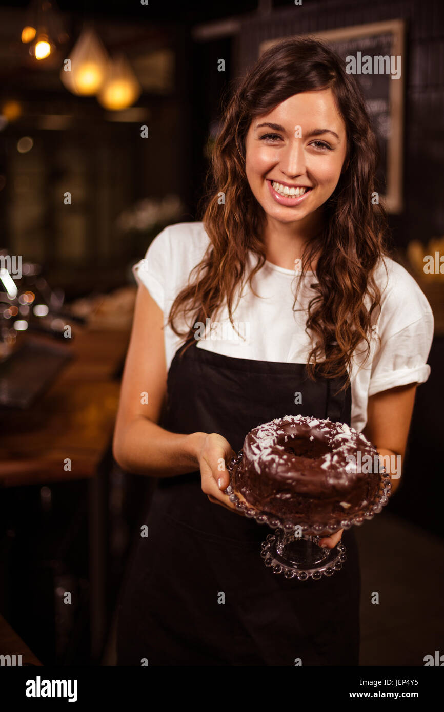 Pretty waitress presenting a chocolate cake Stock Photo - Alamy