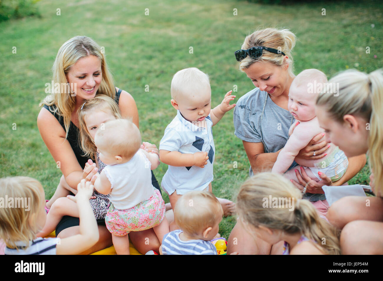 Women with children on grass Stock Photo - Alamy