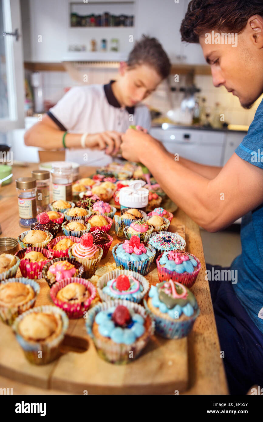 Young men making cupcakes Stock Photo - Alamy