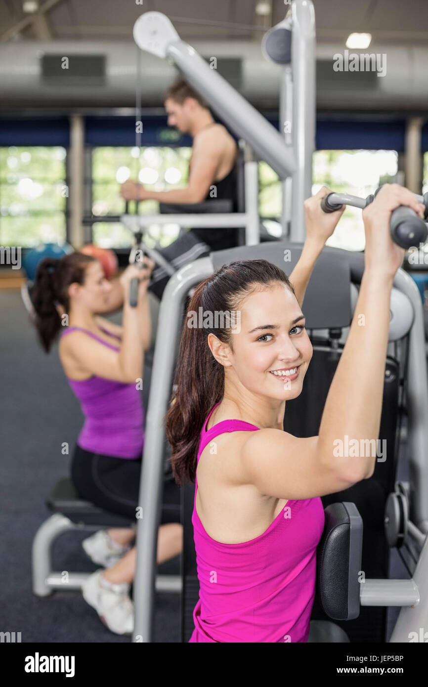 Fit woman using weight machine Stock Photo - Alamy