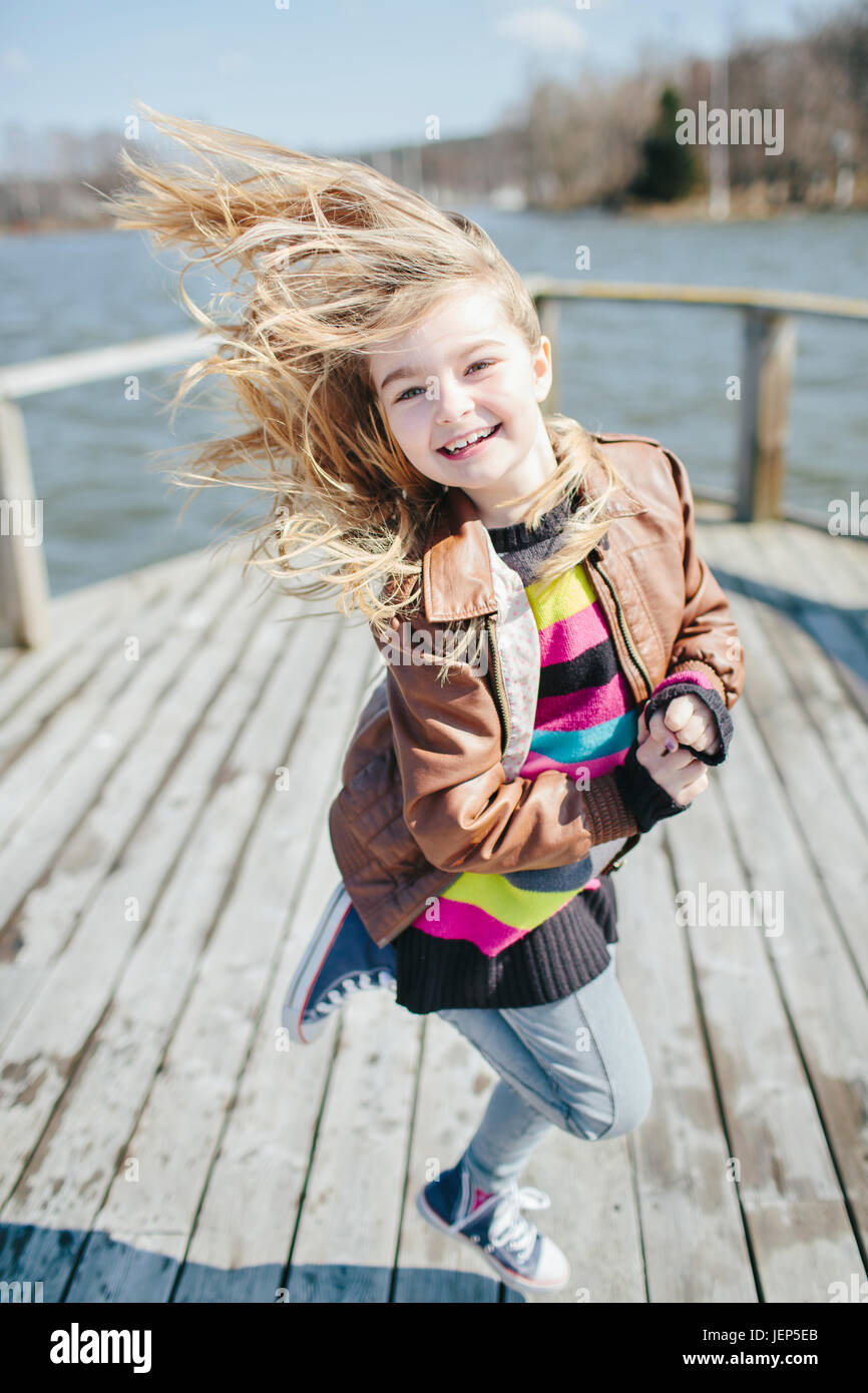 Jumping girl on jetty Stock Photo - Alamy