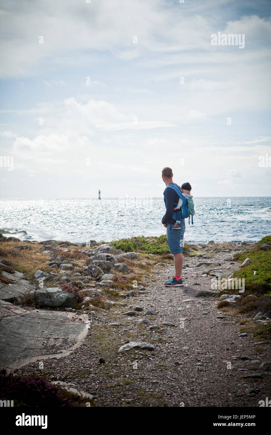 Father with baby in carrier at sea Stock Photo - Alamy