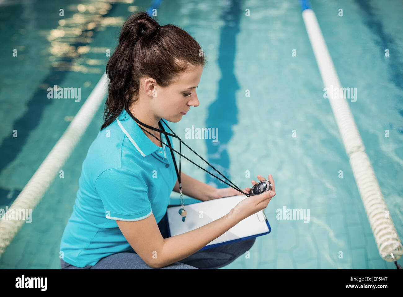 Trainer woman holding a stopwatch Stock Photo - Alamy