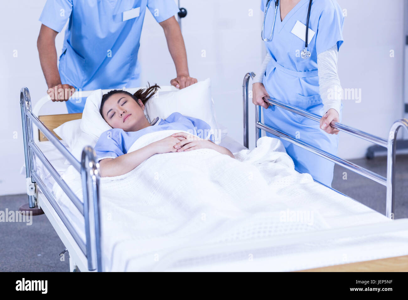 Doctors standing near patient bed Stock Photo - Alamy