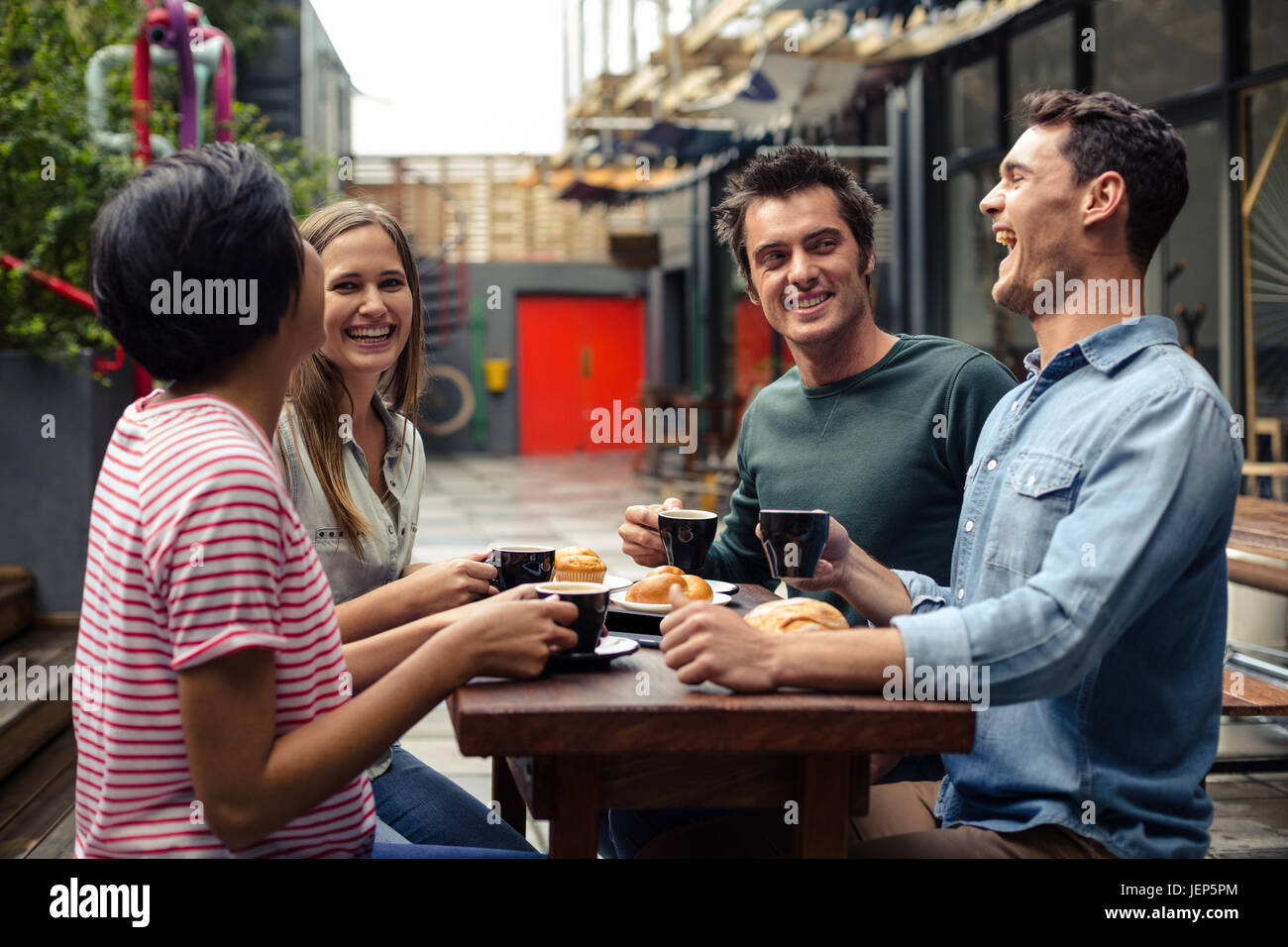 Happy friends having coffee together Stock Photo - Alamy