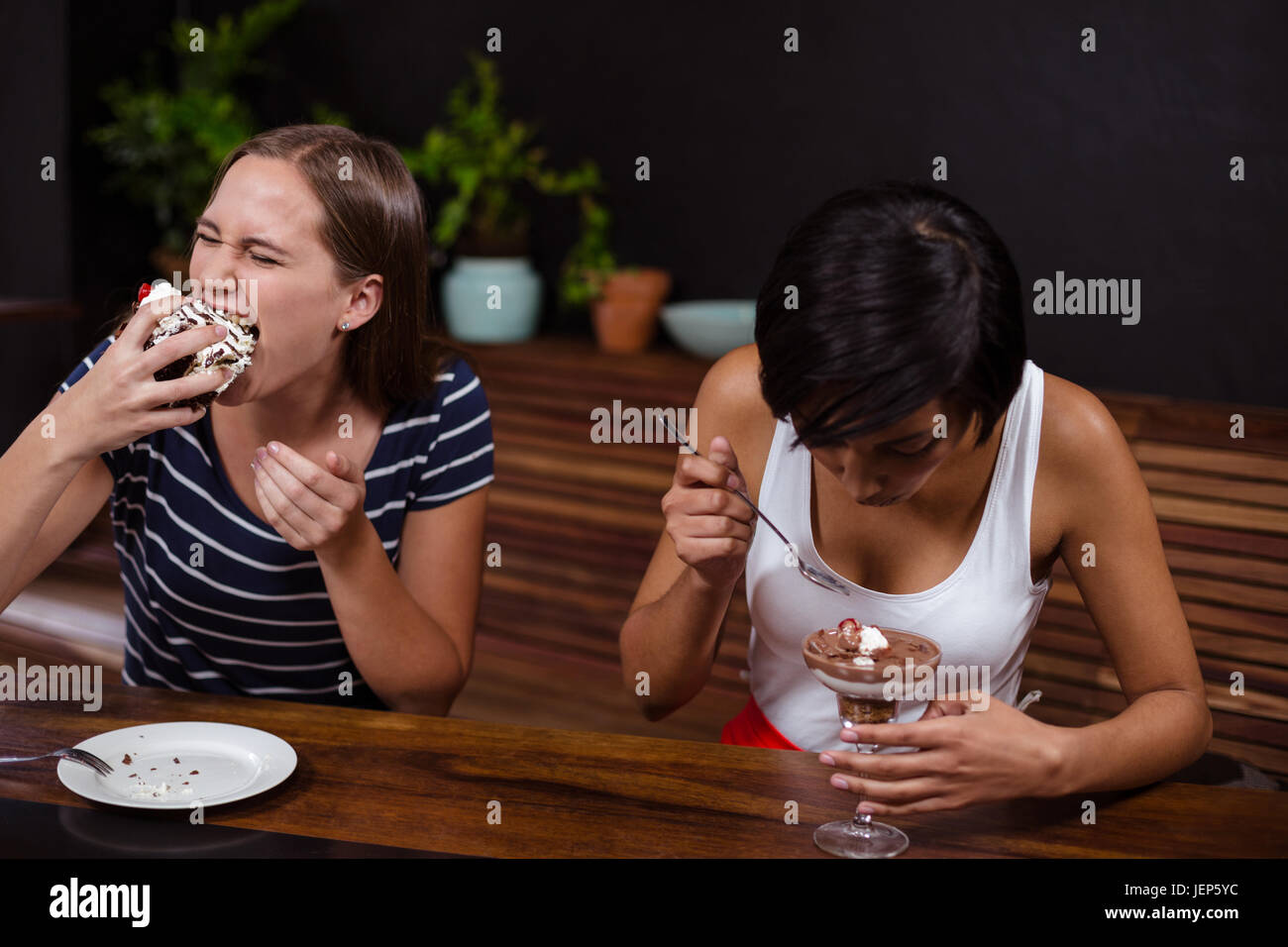 Pretty women eating desserts Stock Photo - Alamy